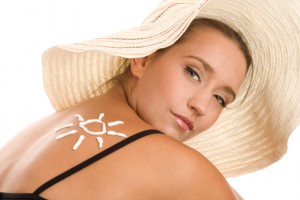 Frau mit Hut und Sonnencreme