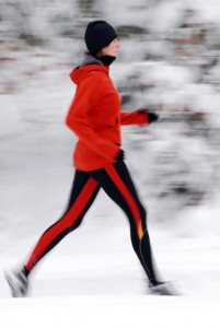 Frau joggt im Winter bei Schnee