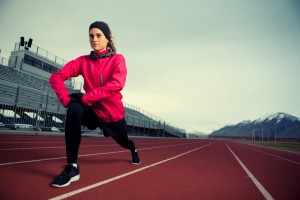 Frau macht Dehnübungen vor einem Lauf